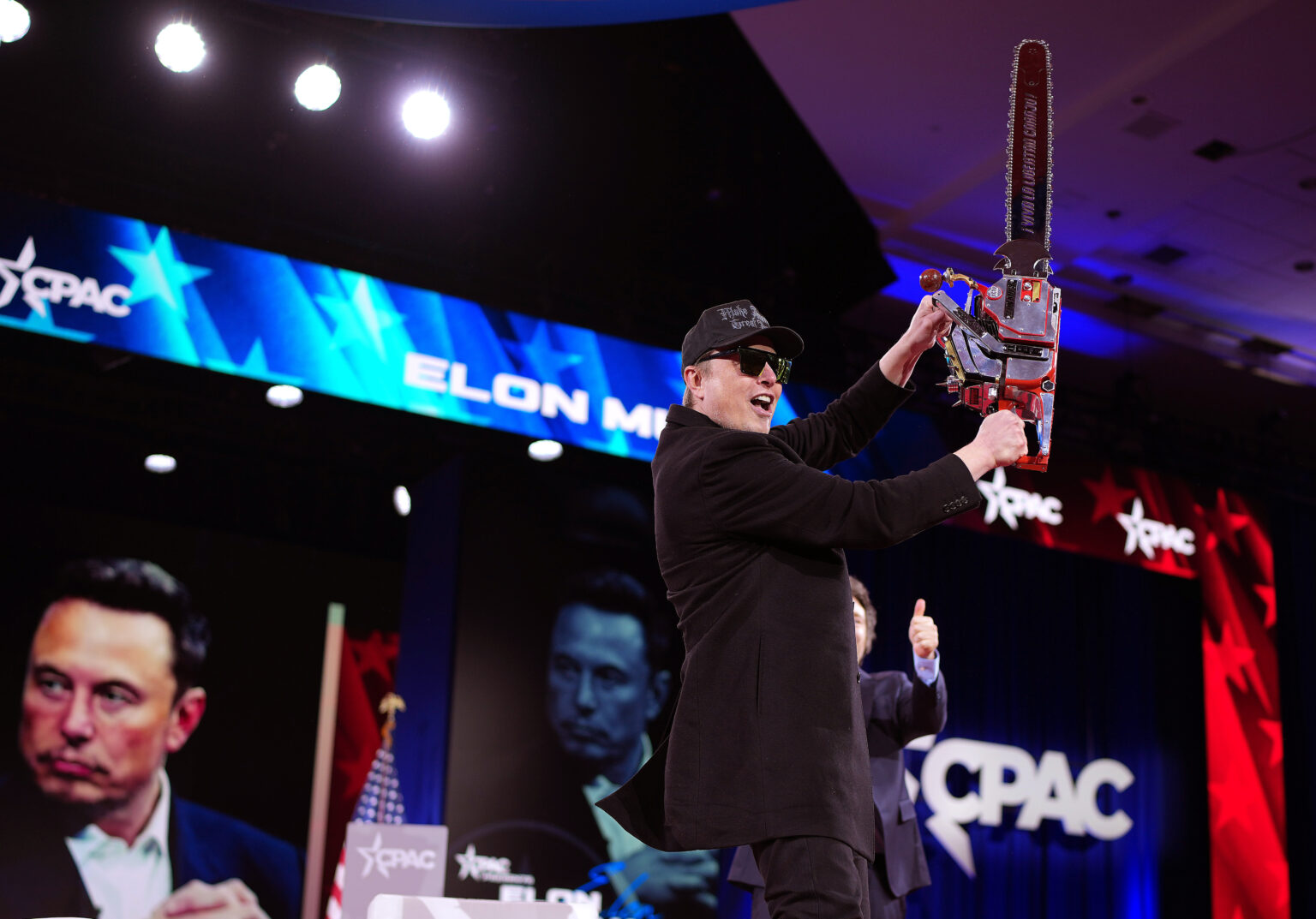 Elon Musk wields chainsaw on stage as ex sends him grim message ...